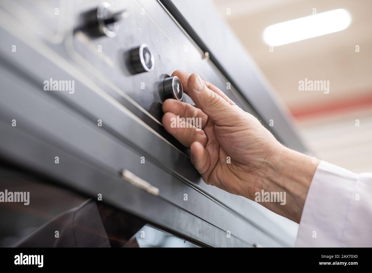 Close-up of unrecognizable man pushing button with arrow down while ...