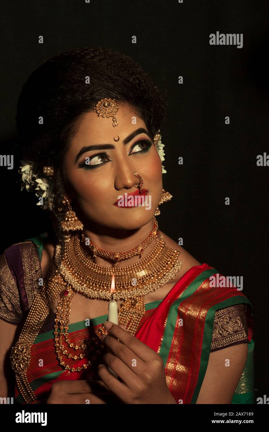 Beautiful Indian Marathi bride in red saree wearing jewelry Stock Photo ...