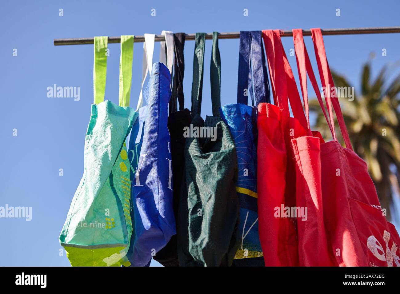 Low angle shot of colorful eco-friendly reusable cloth bags hanging on ...