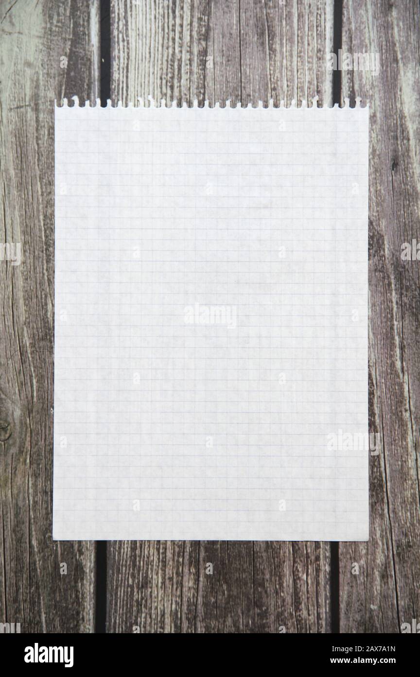 White sheet checker paper torn from a spiral notebook lies on the ...