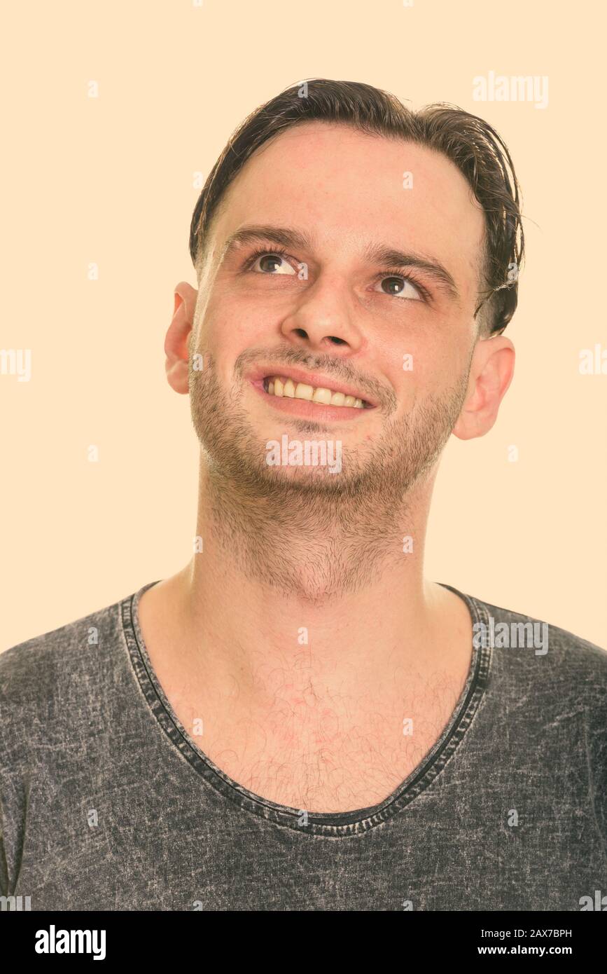 Face of happy young man smiling while thinking Stock Photo - Alamy