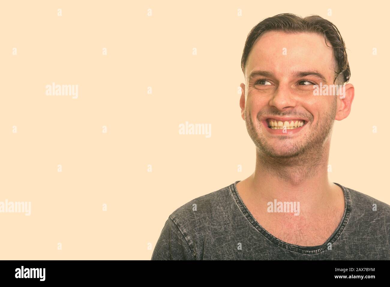 Studio shot of young happy man smiling while thinking Stock Photo - Alamy