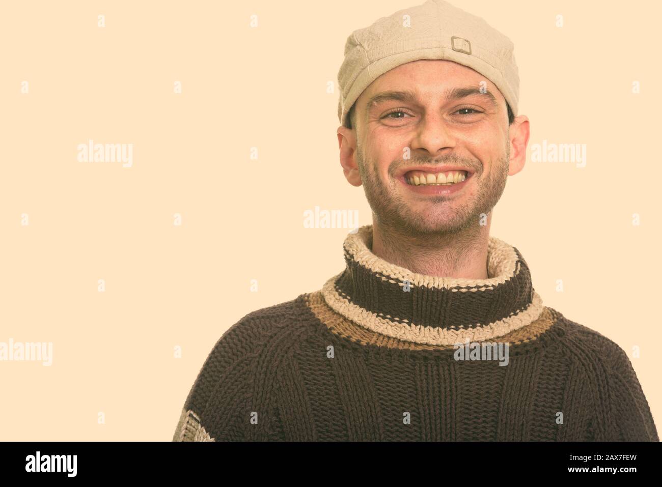 Studio shot of young happy man smiling while wearing hat Stock Photo ...