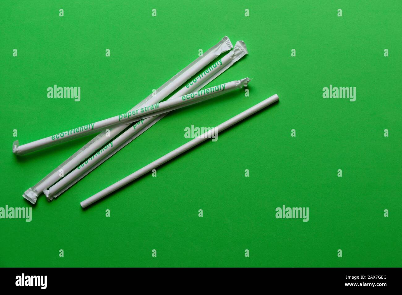 Unused paper straws in package on green background Stock Photo - Alamy