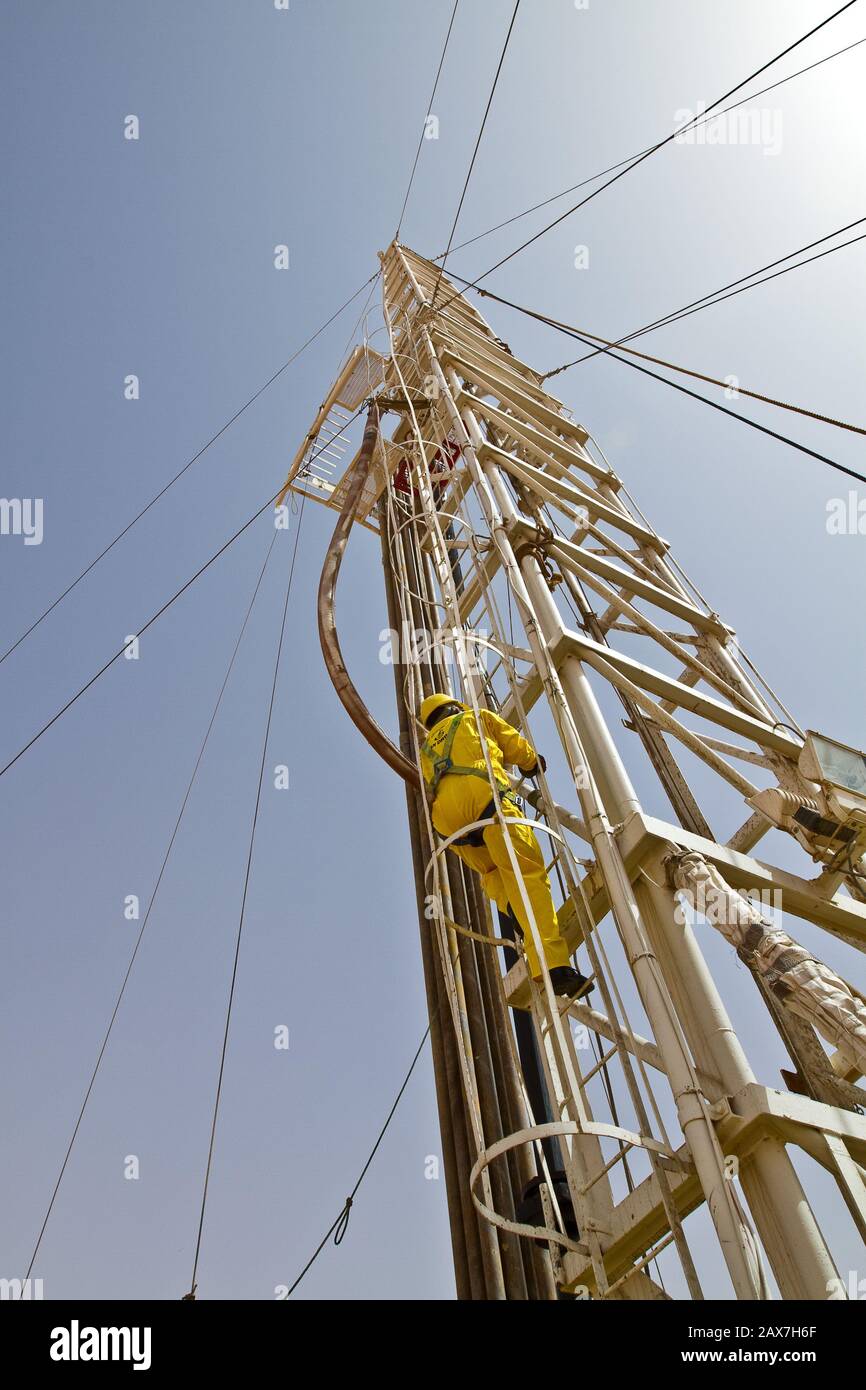 A worker with a safety harness on climbs up a mast Stock Photo - Alamy