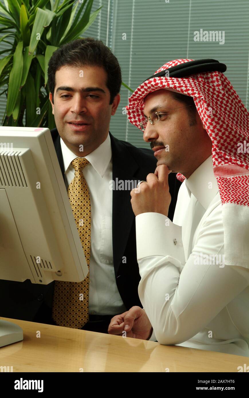 Two bankers looking at a computer monitor Stock Photo - Alamy