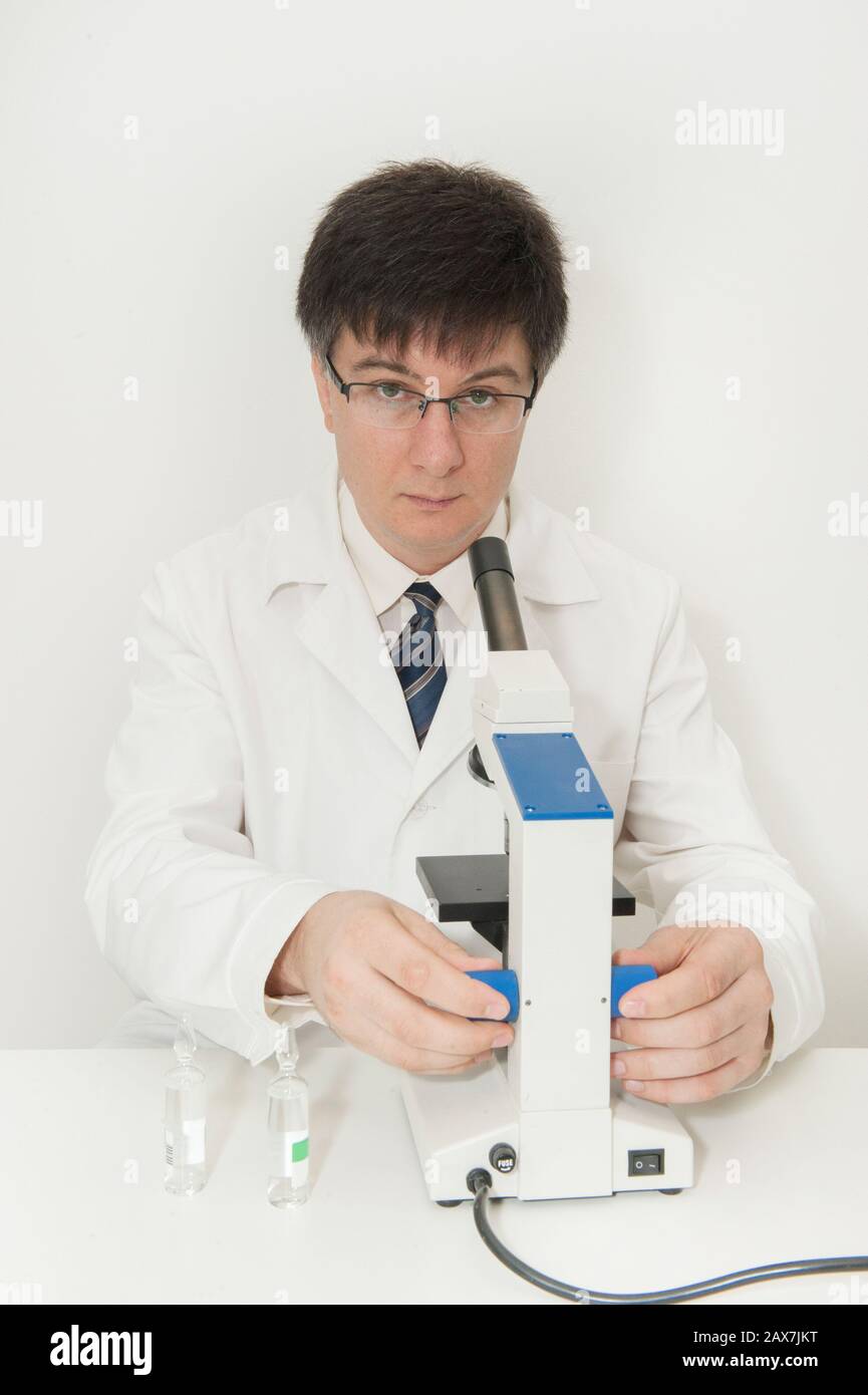 A man in a white coat doctor with a microscope Stock Photo - Alamy
