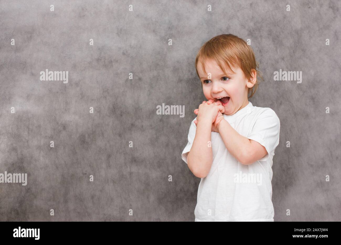 Little boy with happy smile on face joyfully clapping hands and shy ...