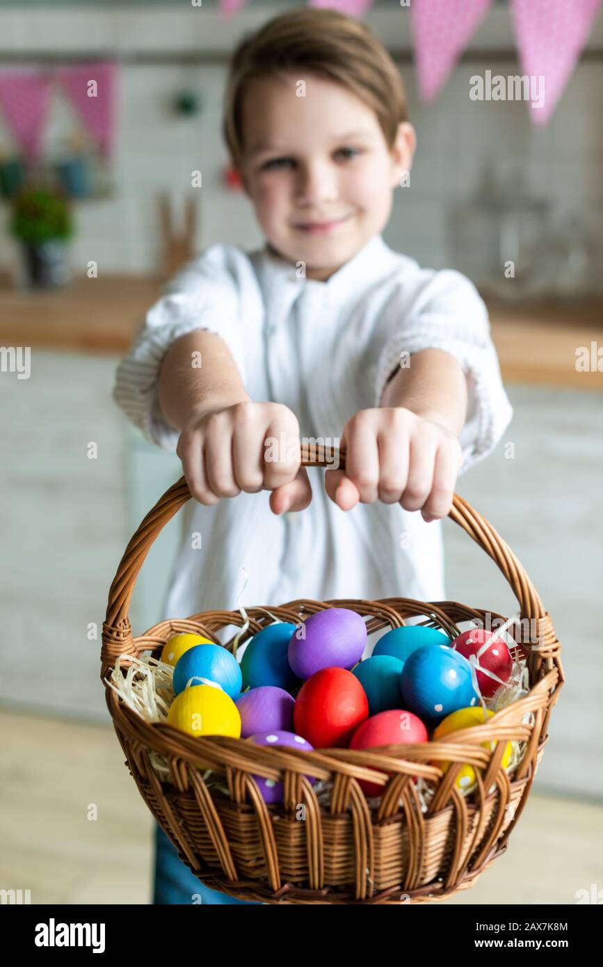 Portrait of little boy holding a basket with Easter eggs/ Focus on ...