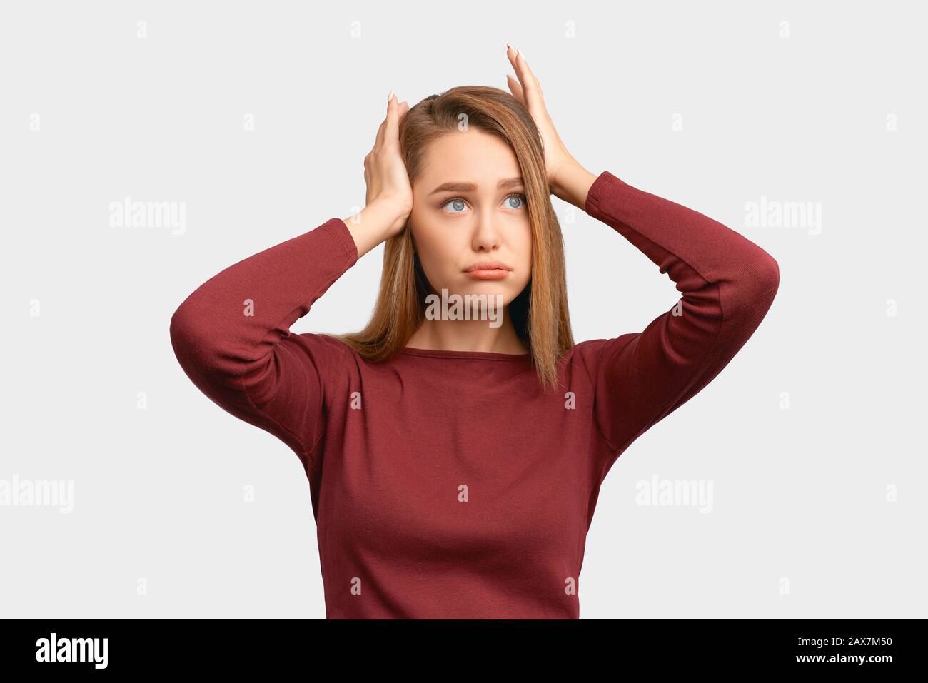 Upset girl keeps hands on temples, pout Stock Photo - Alamy