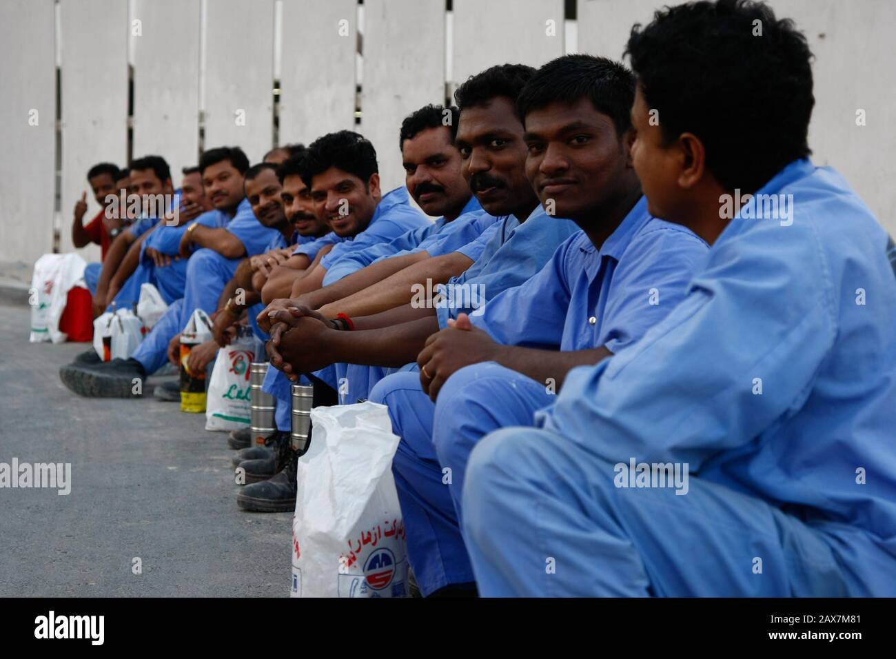 Construction workers wait for their bus at a construction site in Dubai ...