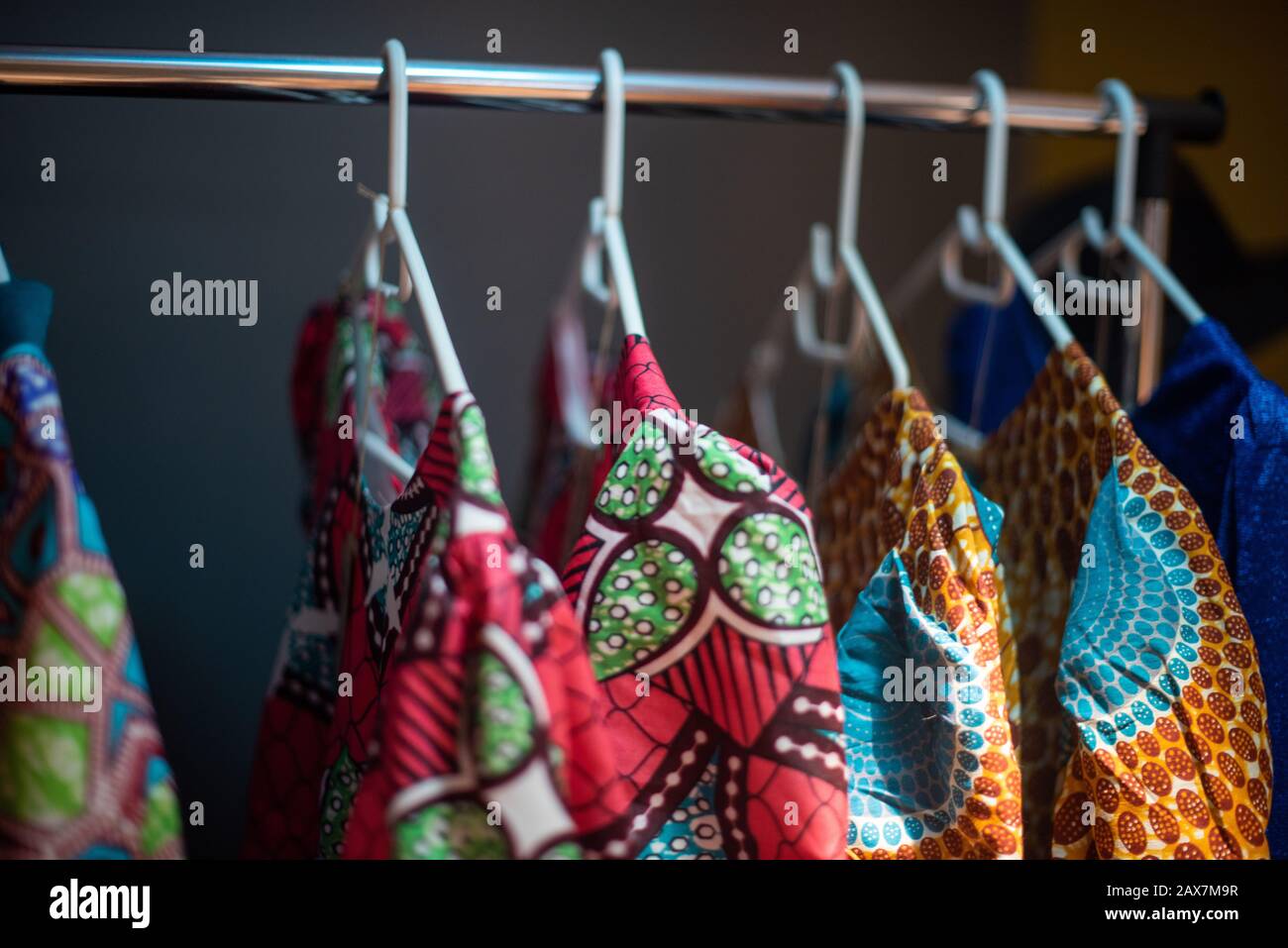 Assortment of African print clothing hanging on railing Stock Photo - Alamy