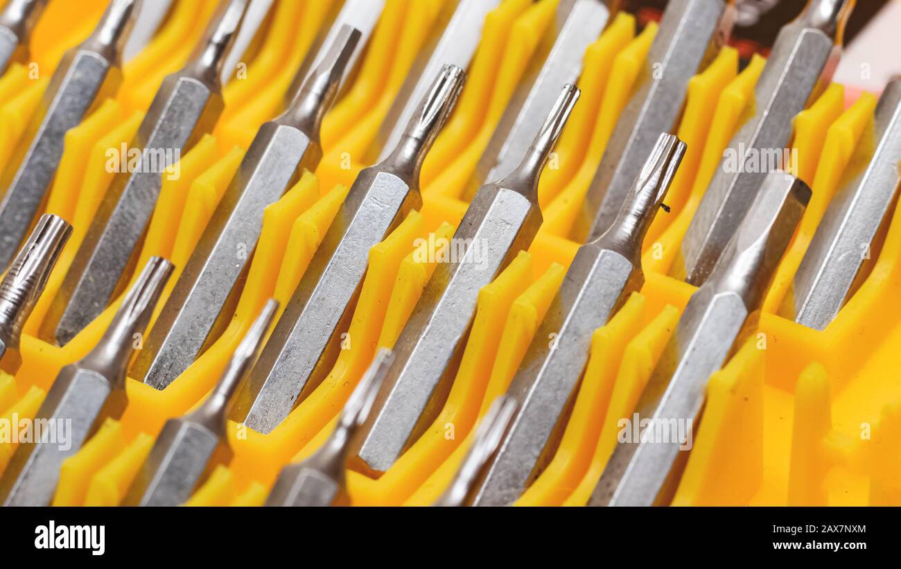 Screwdriver bits in a yellow plastic container close up Stock Photo - Alamy