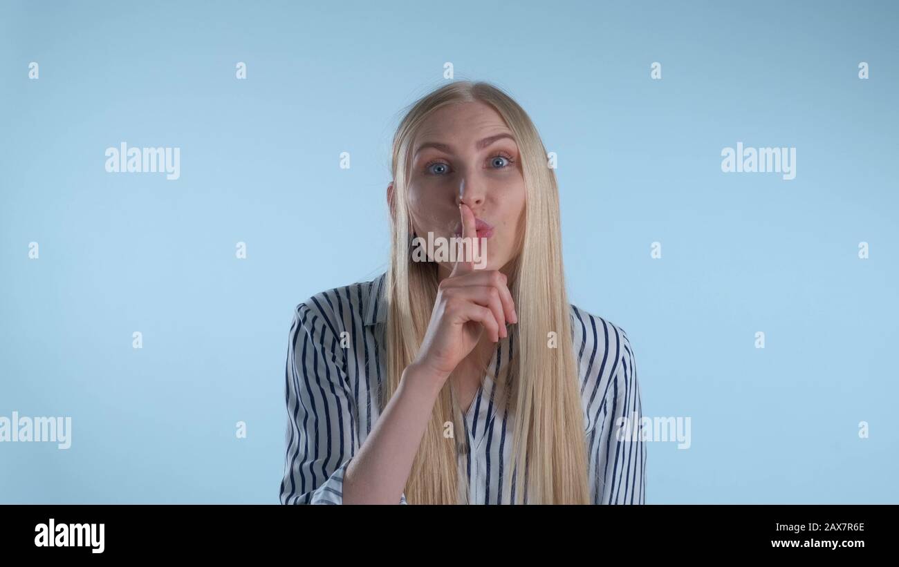 Amazing blonde woman making silence gesture on blue background. She ...