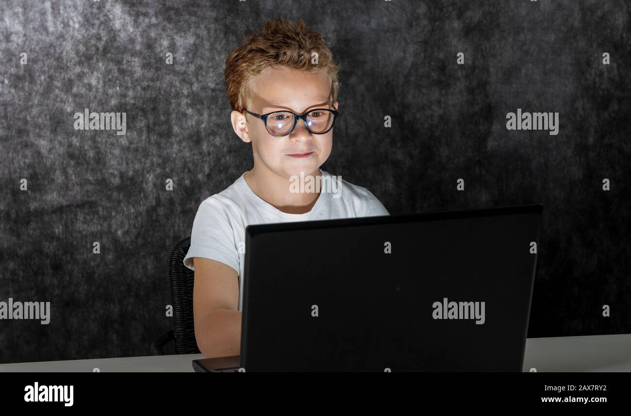 Happy boy sitting with a laptop computer Stock Photo - Alamy