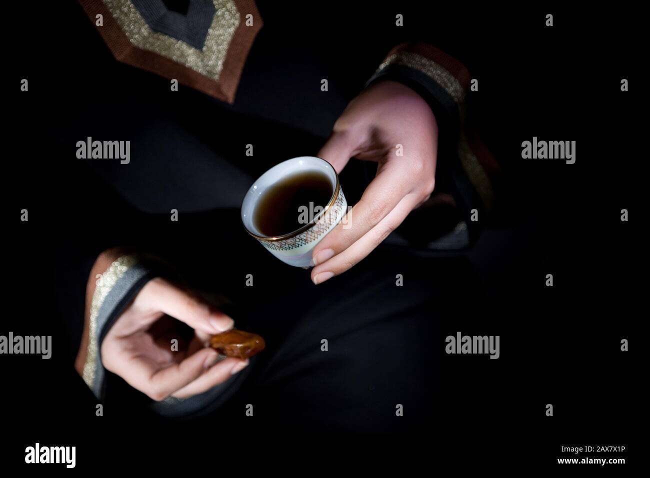 An arab woman holding a bowl of dates and gawa (Arabian Coffee Stock ...