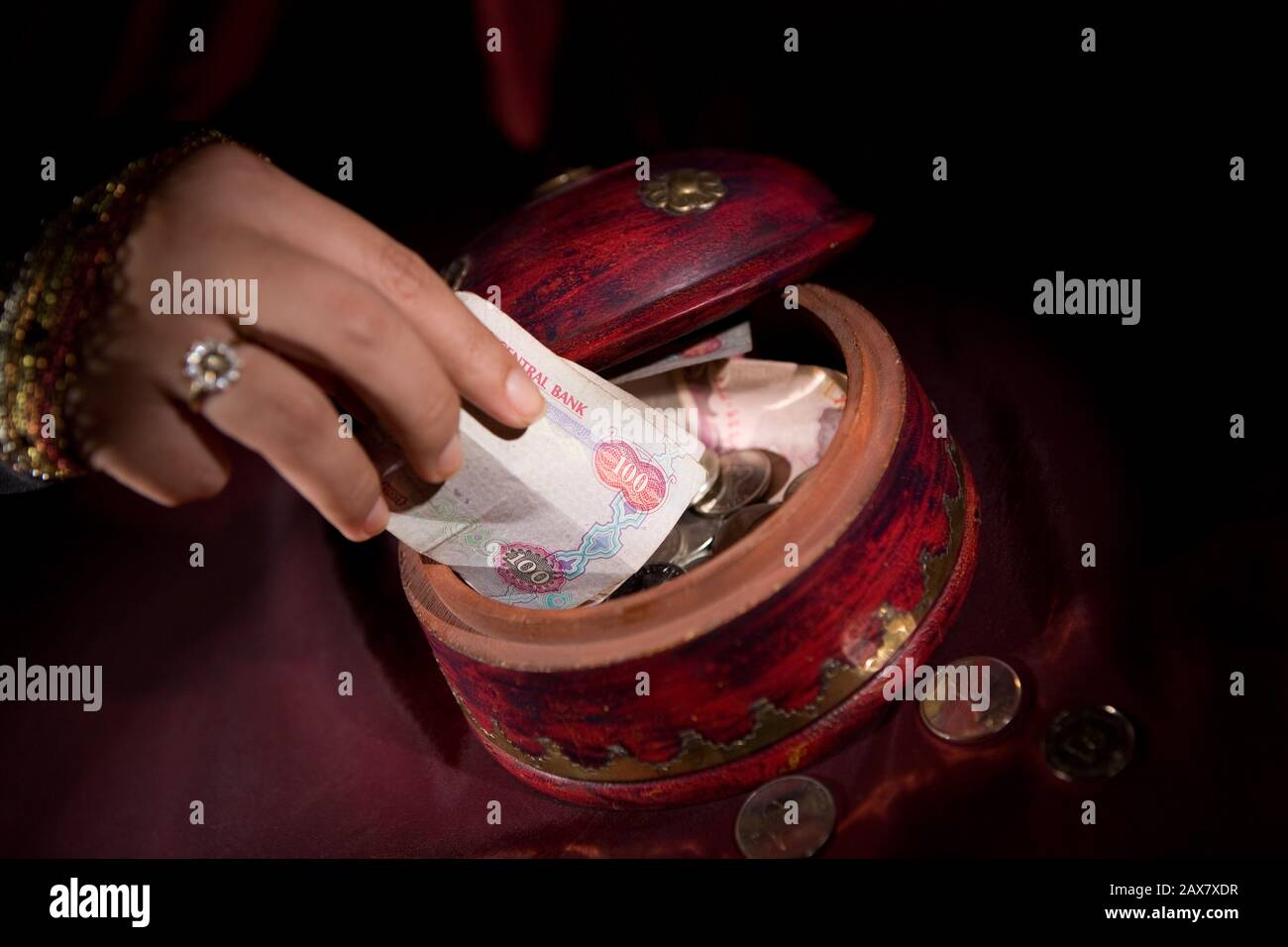 An arab woman putting money into a box Stock Photo - Alamy