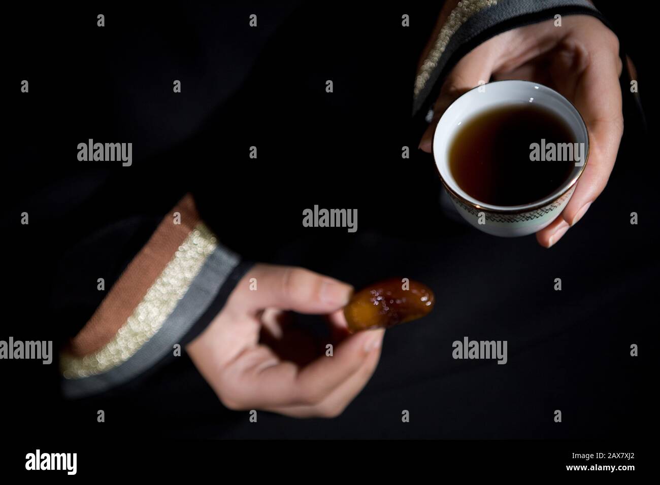 An arab woman holding a bowl of dates and gawa (Arabian Coffee Stock ...