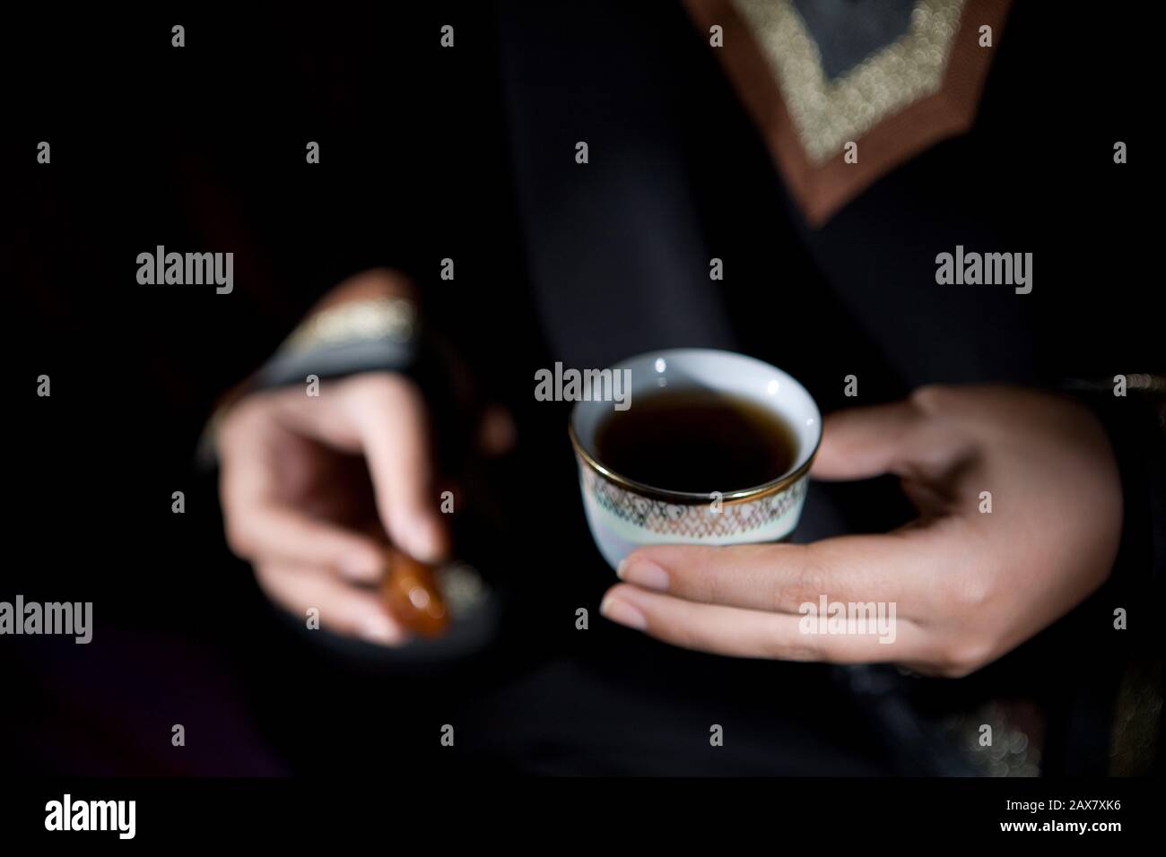 An arab woman holding a bowl of dates and gawa (Arabian Coffee Stock ...