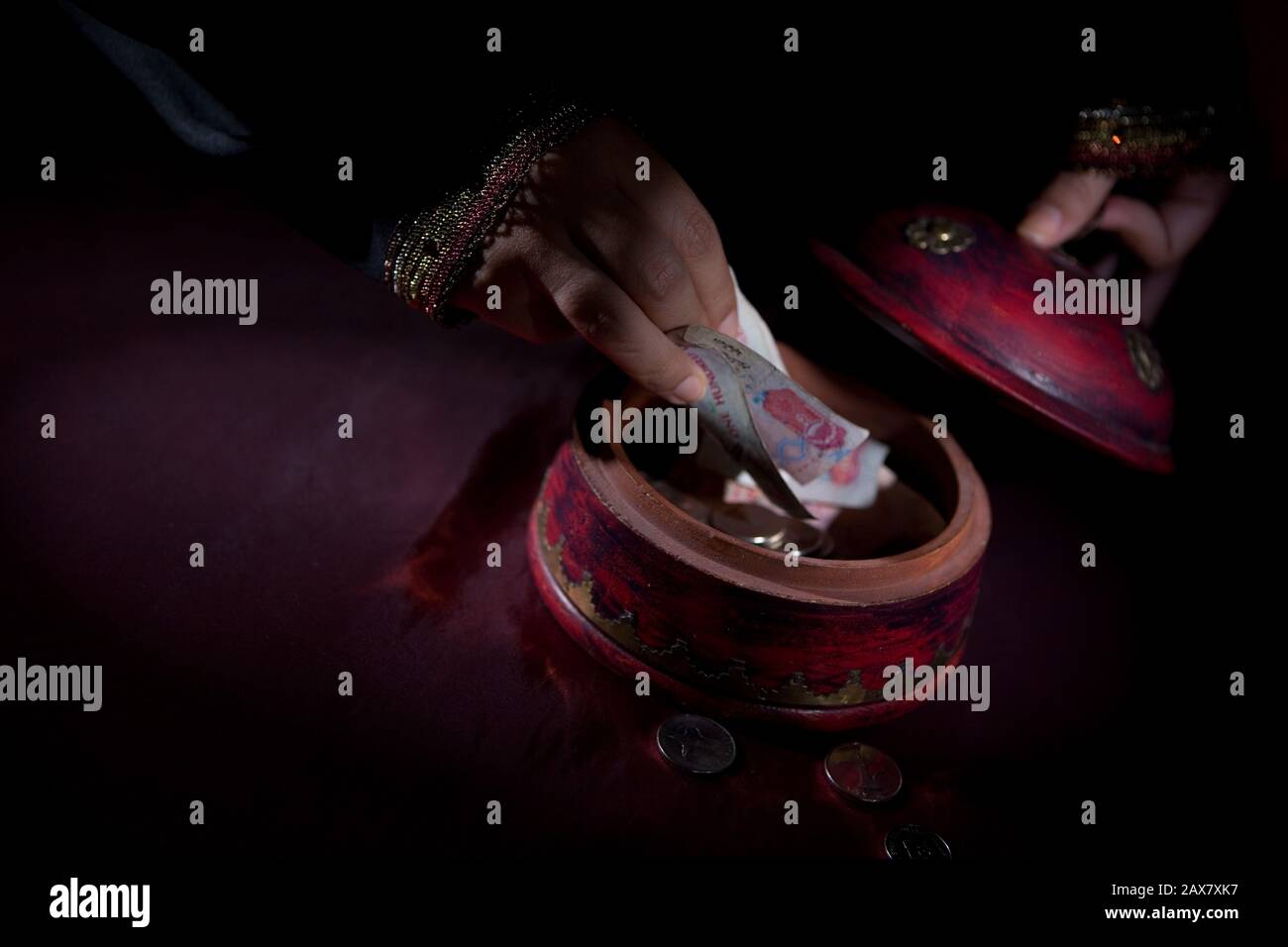 An arab woman putting money into a box Stock Photo - Alamy