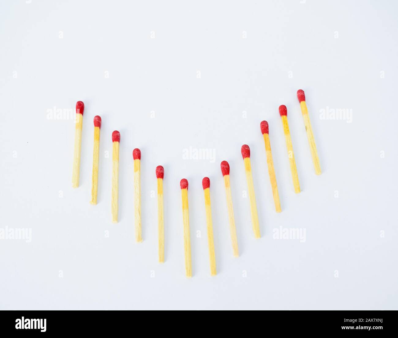 Bunch of wooden match sticks arranged in a arrow shape on an isolated ...