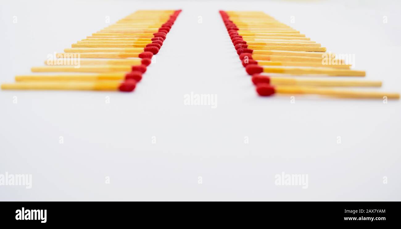 Wooden red match sticks arranged in two similar row while facing each ...