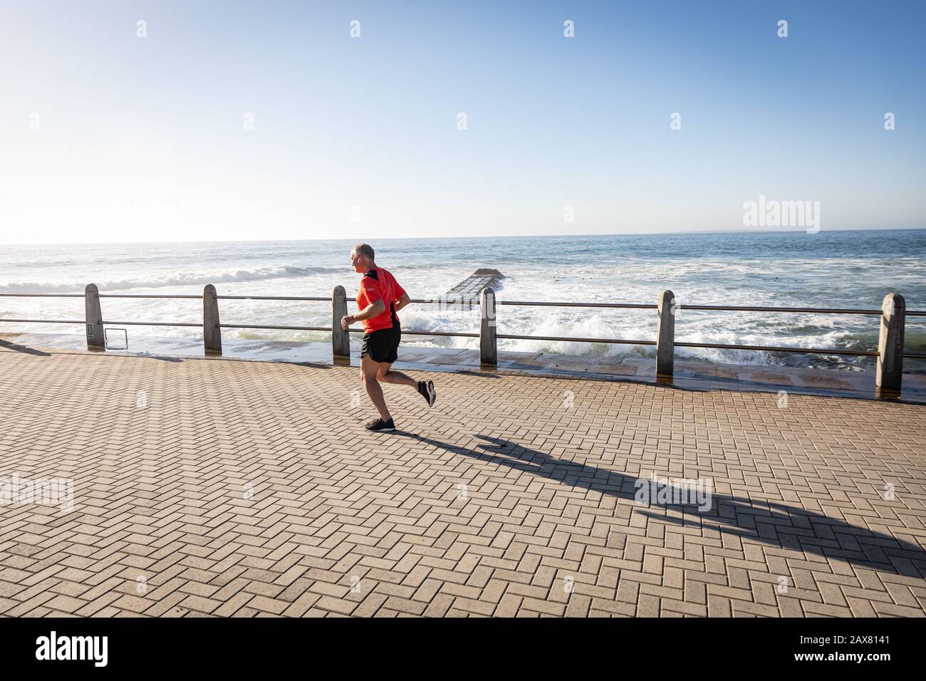 Jogger running on seaside Stock Photo - Alamy