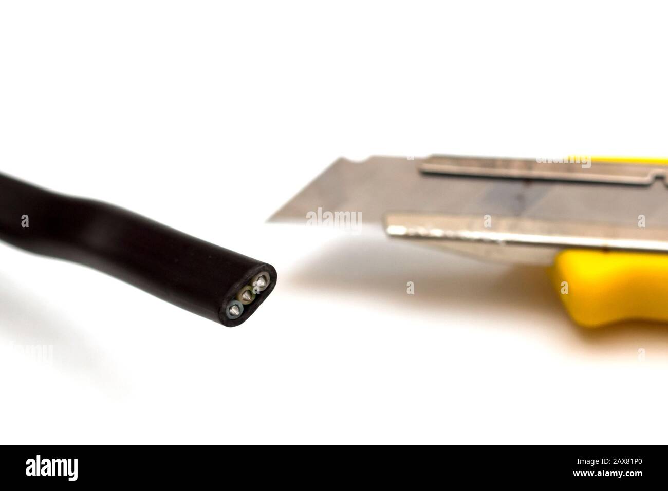 Cut off black cable and clerical knife Stock Photo - Alamy