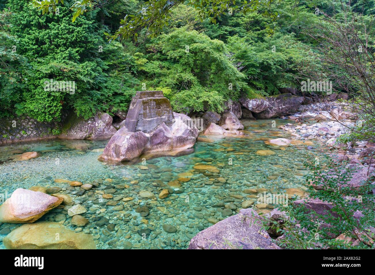 Crystal clear river flowing over rocks in the forest Stock Photo - Alamy