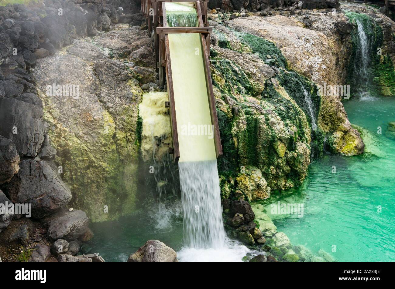 Mineral water from hot spring flowing over wooden box in Kusatsu, Japan ...