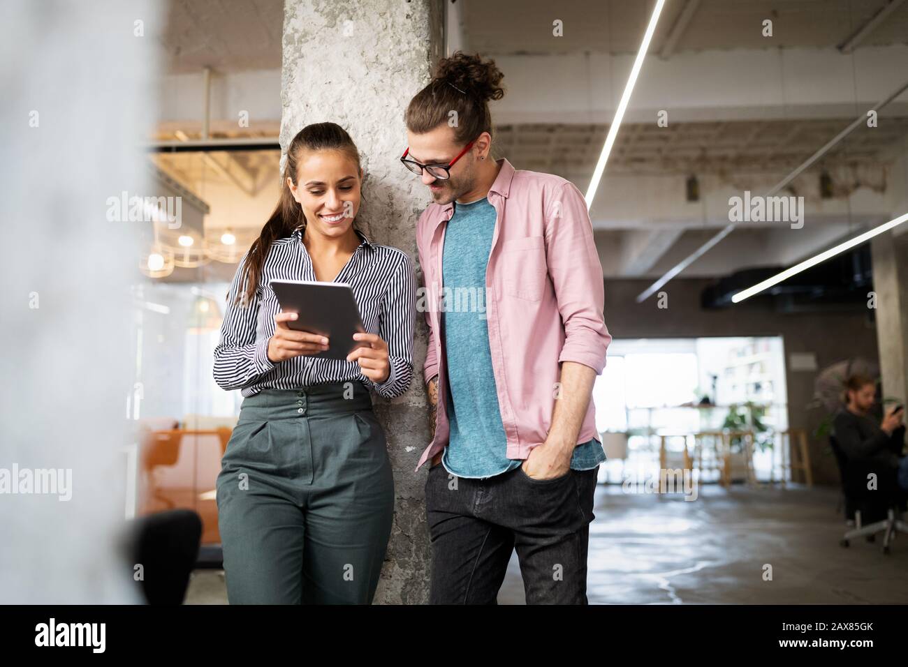 Happy people talking and browsing internet during a break at workplace ...