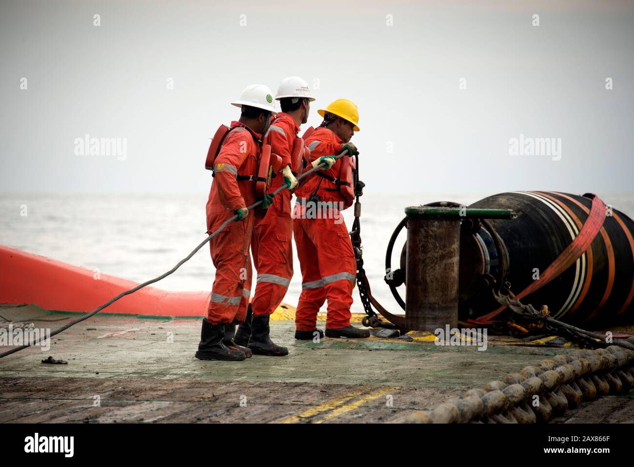 Deck crew working hose connection on deck for crude oil transfer from ...