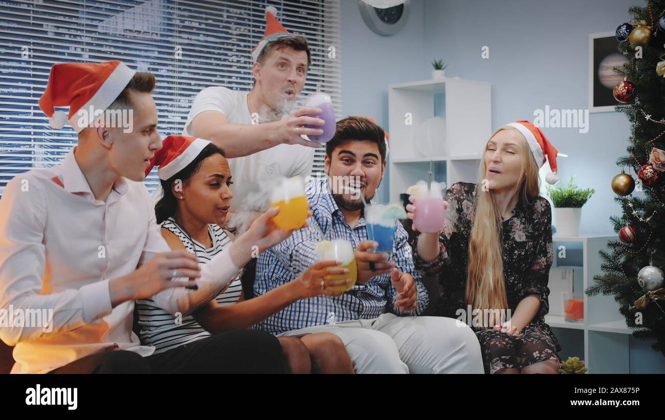 Group of mixed race friends celebrating Christmas in confetti blowing ...