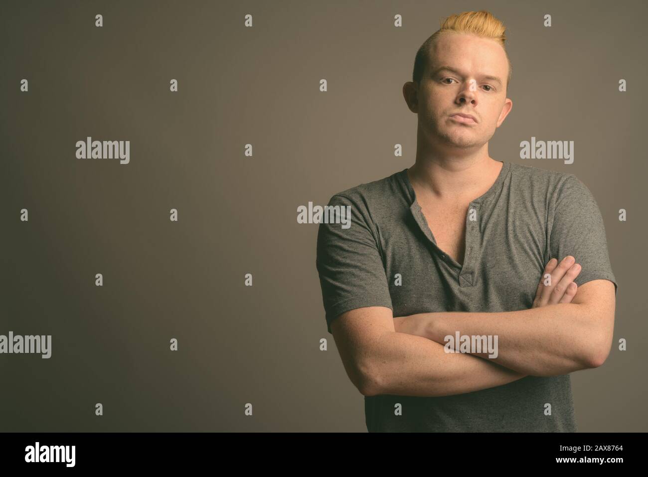 Man with Mohawk hairstyle and blond hair against gray background Stock ...