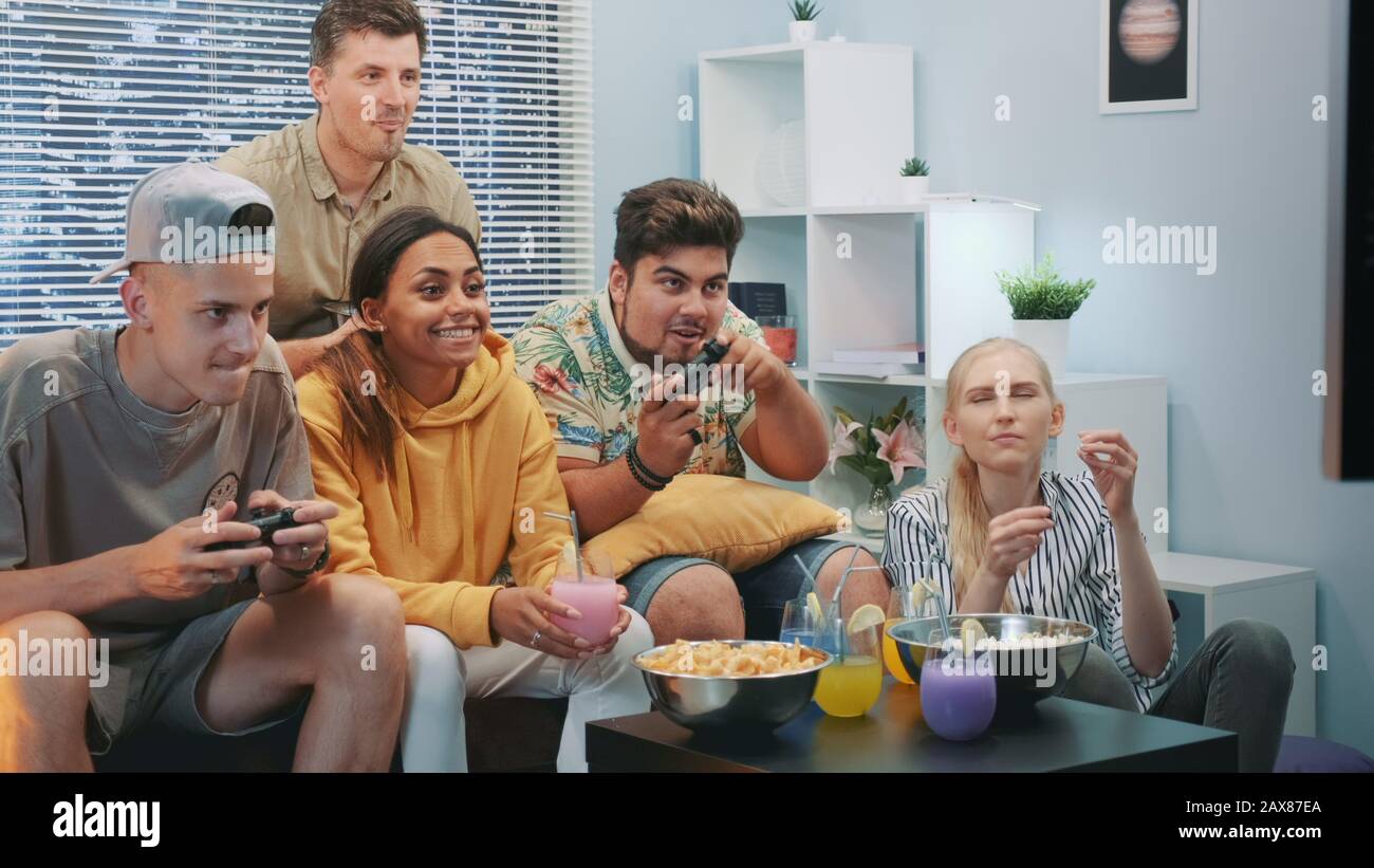 Close up of two guys playing video console game, one of them wins ...