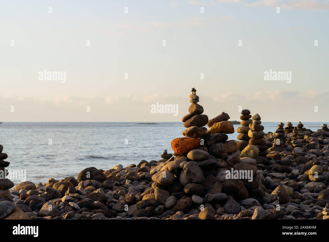 Balanced stone pyramide on shore of the ocean at dawn. Sea pebbles ...