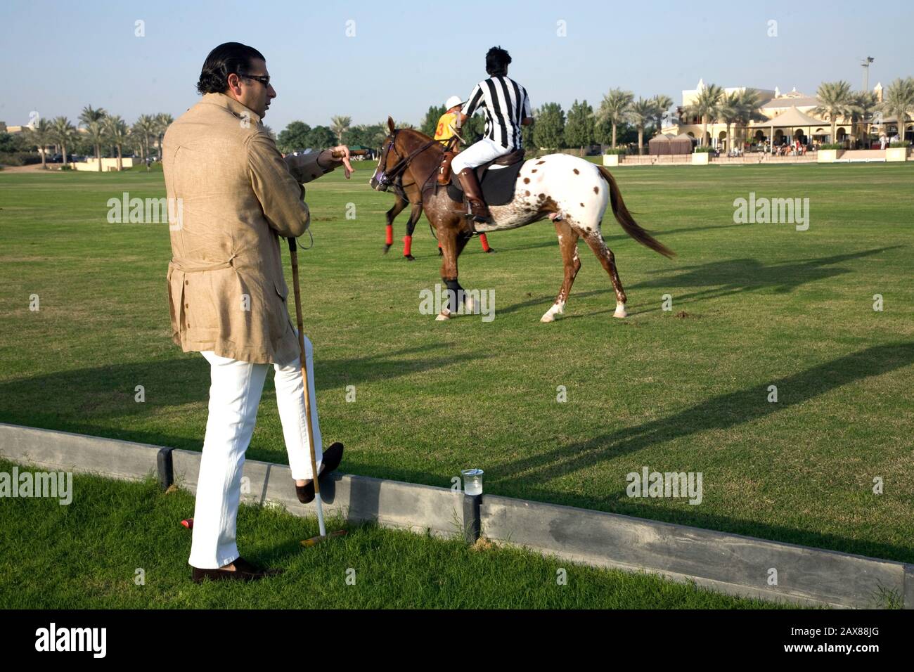 A spectator watches the action of a late afternoon polo game at the ...