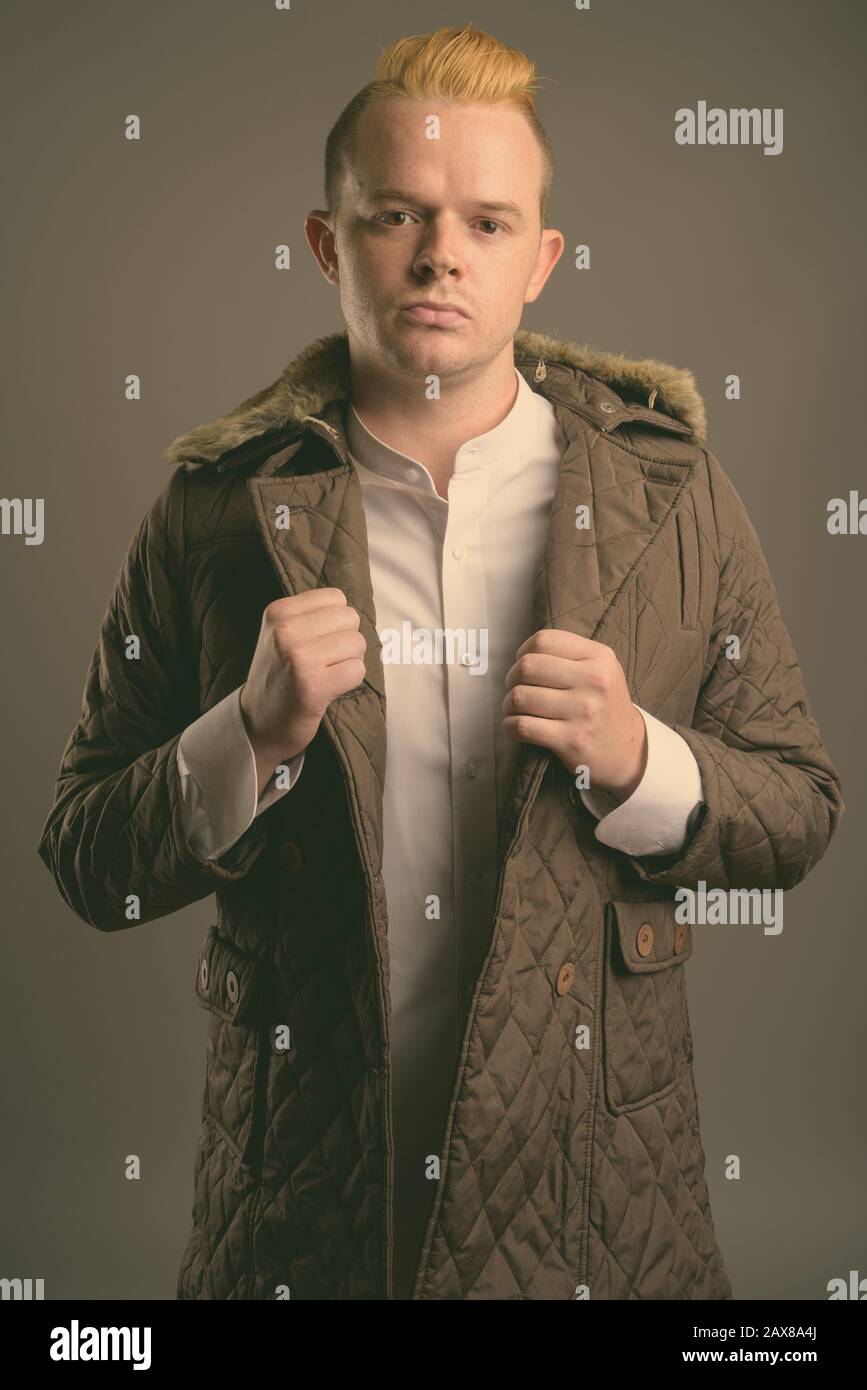 Man with Mohawk hairstyle and blond hair against gray background Stock ...