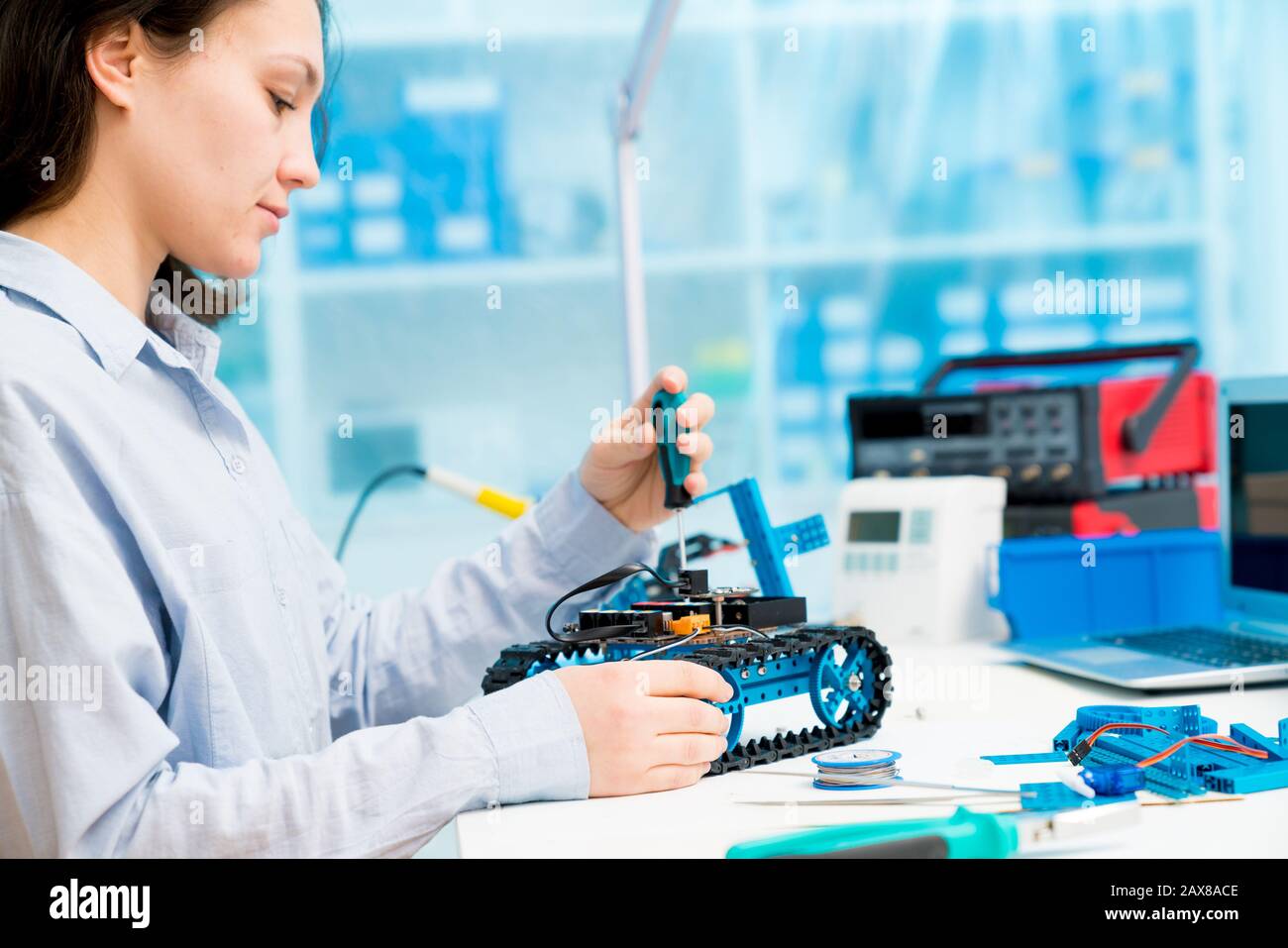 Student woman in robotics laboratory working on project mechatronics ...