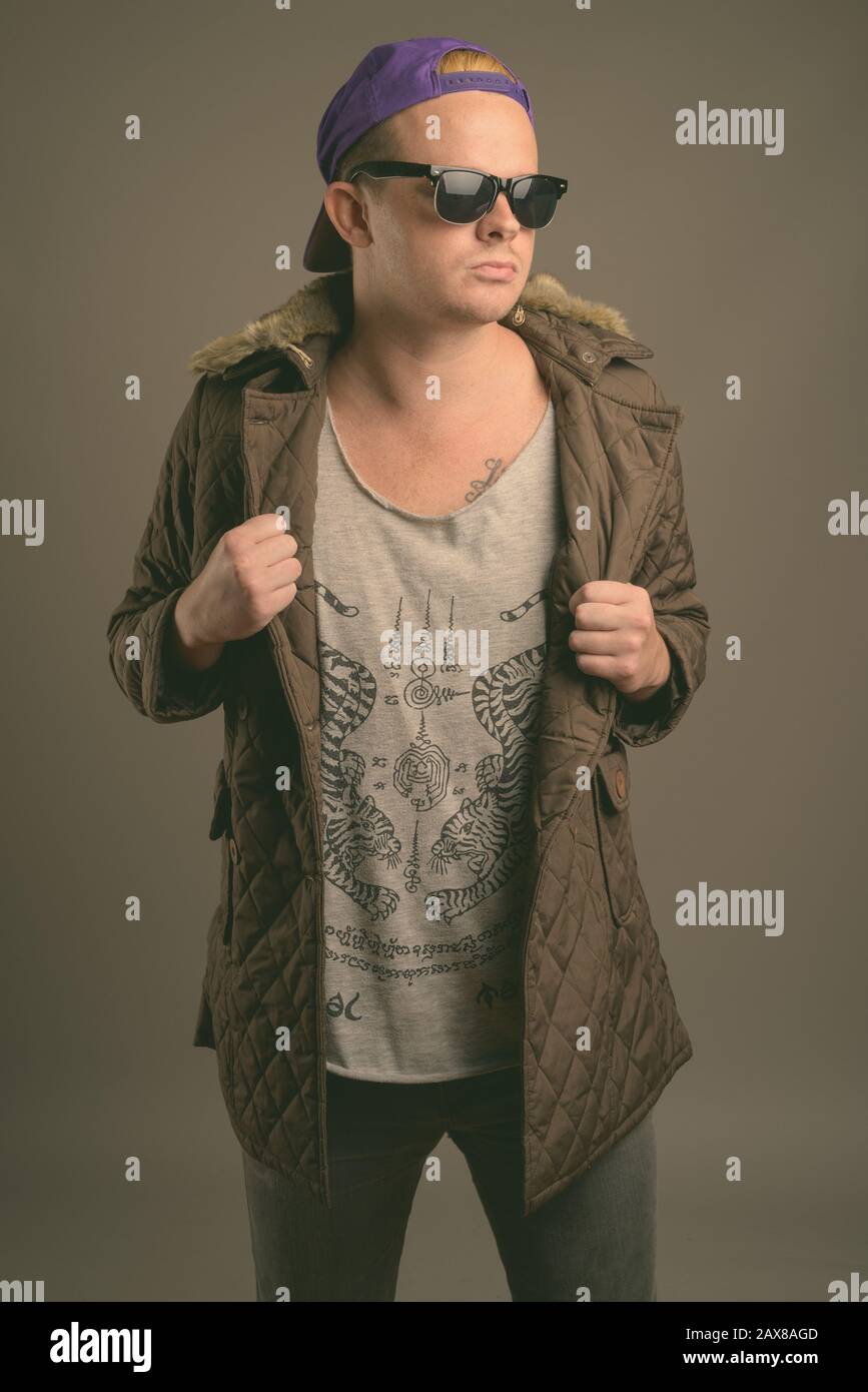 Man with Mohawk hairstyle and blond hair against gray background Stock ...