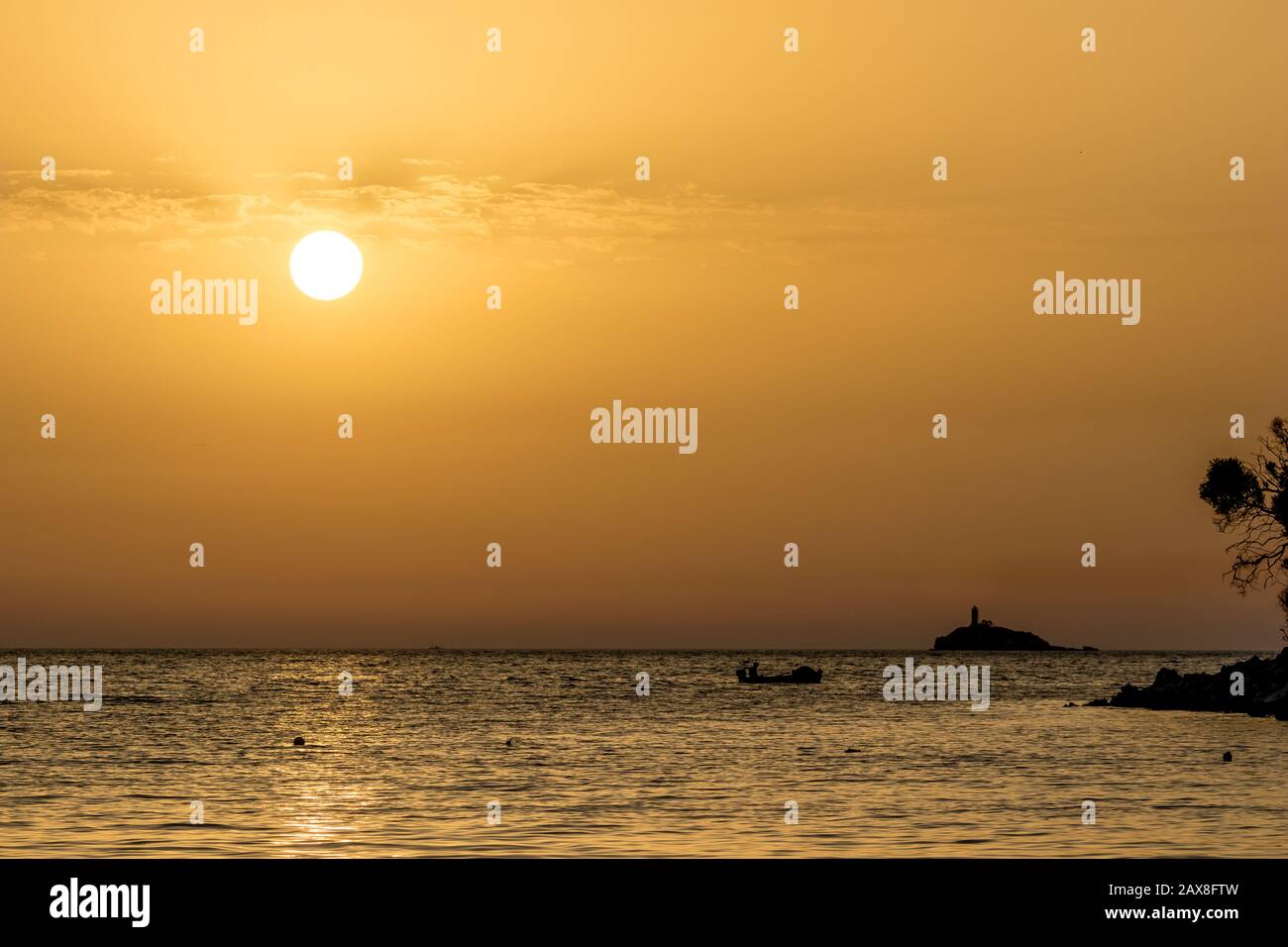 Focus on round setting Sun. Boat silhouette. Sun circle at beach at ...