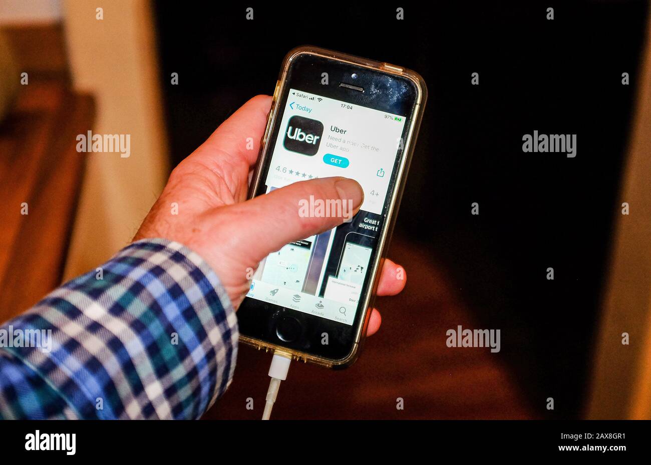 Using a smartphone to download Uber taxi cab app Stock Photo - Alamy