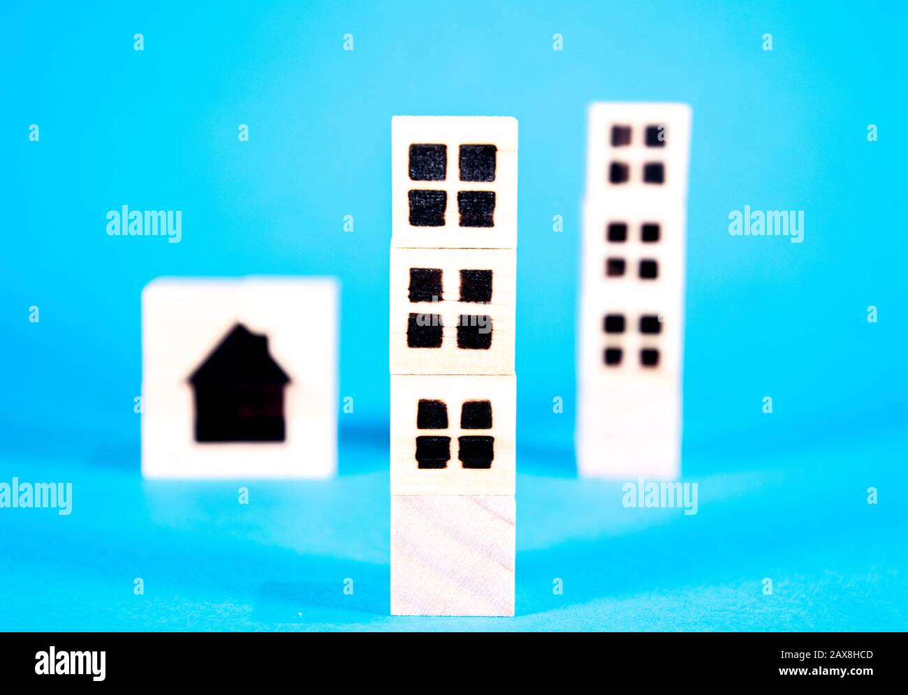 Tower block flats and a house shown on wooden blocks to signify tenancy ...