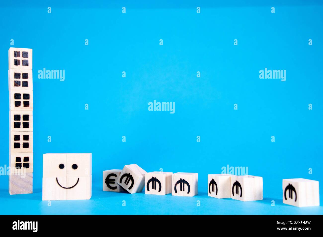 A happy face standing beside fallen price symbol blocks to symbolize ...