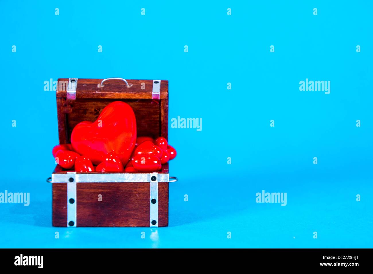 A treasure chest full of love hearts, taken on a bright blue background ...