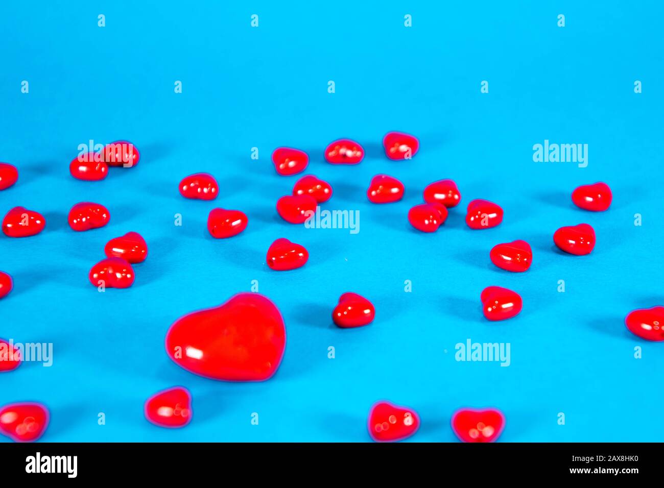 A scattering of love hearts, taken on a bright blue background, with ...