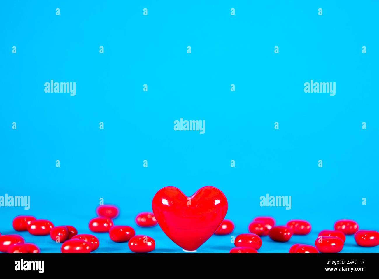 A scattering of love hearts, taken on a bright blue background, with ...