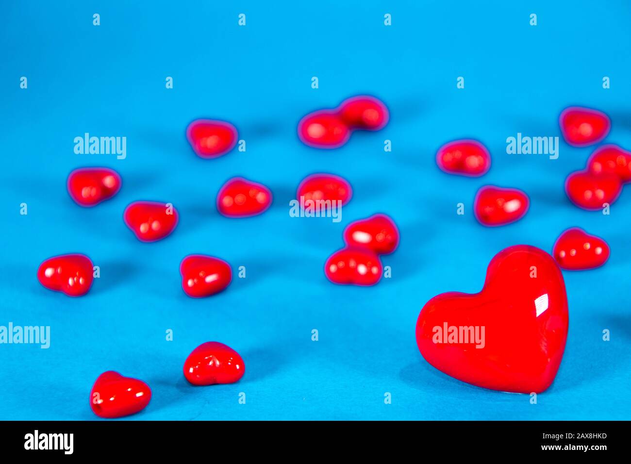 A scattering of love hearts, taken on a bright blue background, with ...