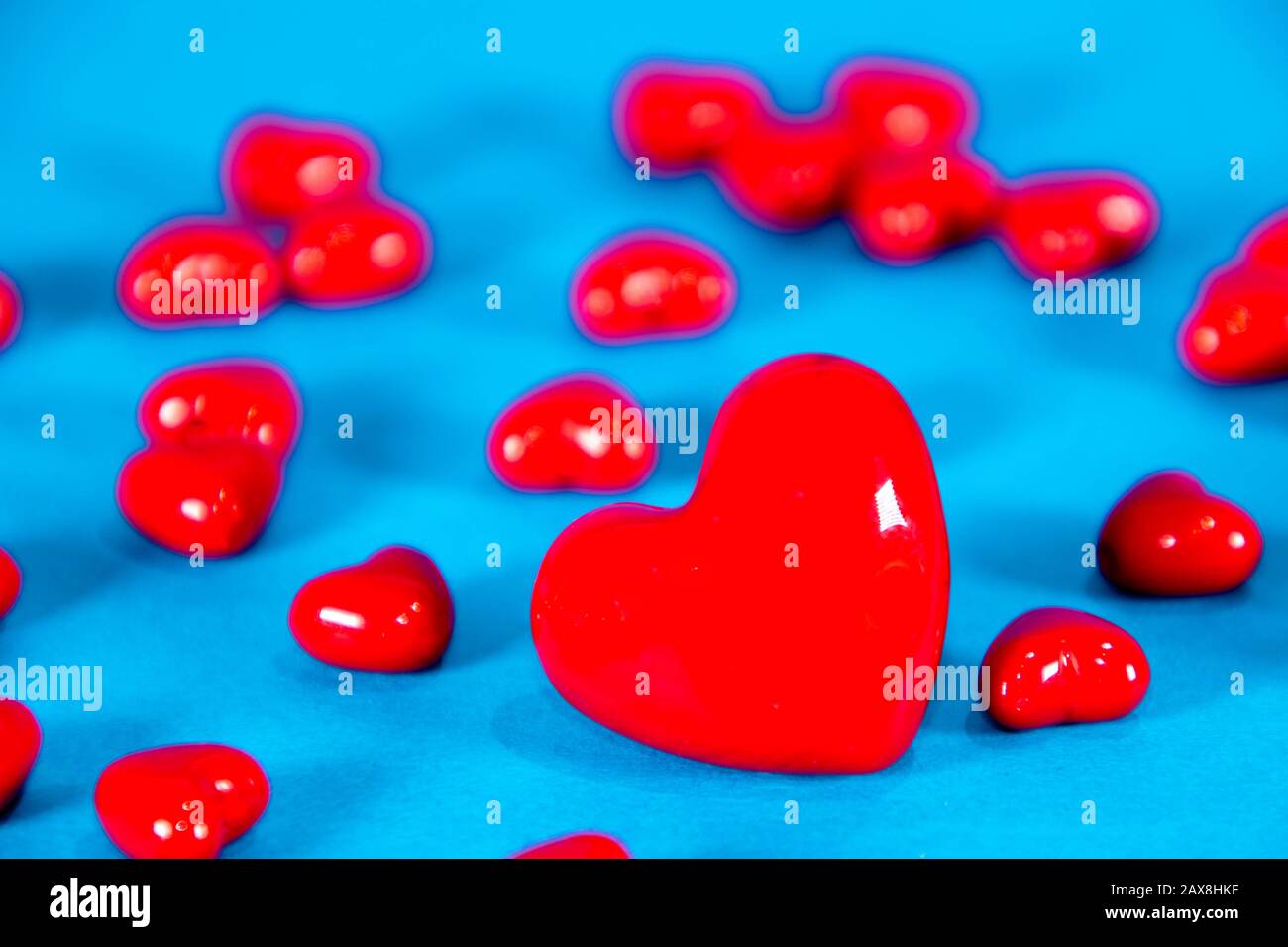 A scattering of love hearts, taken on a bright blue background, with ...