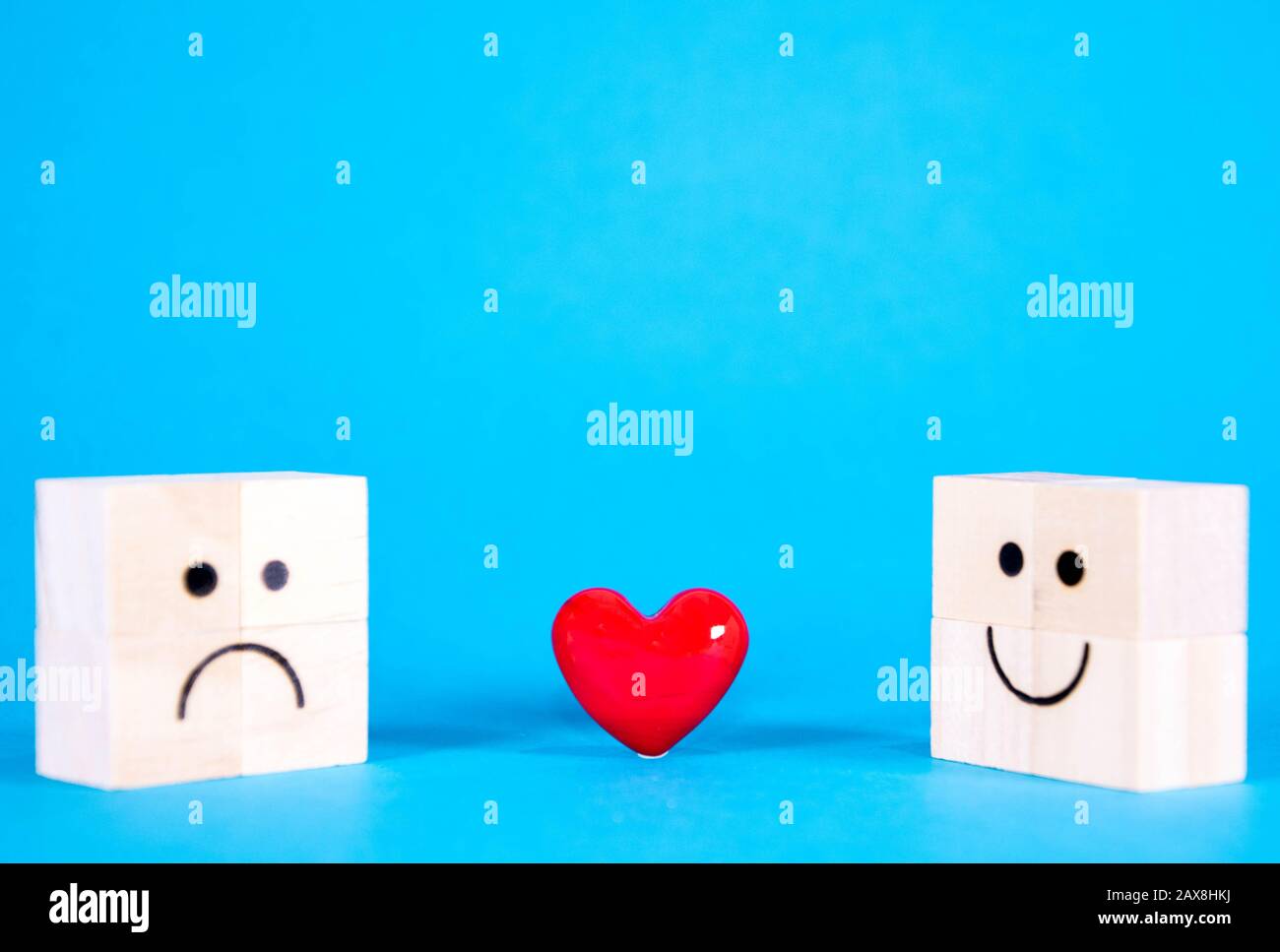 Wooden blocks with a happy face and a sad face, one giving a bright red ...